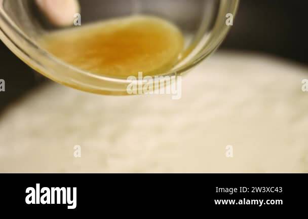 Adding melted chicken fat to mixed milk and water boiling in a frying ...