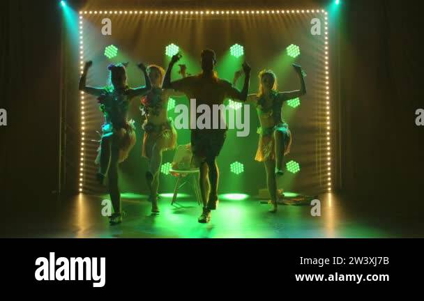 Silhouettes of three charming women dancing around a man. A Hawaiian ...