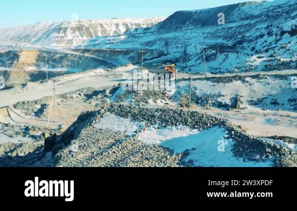 Truck loaded with ore is riding along the mine site. Industrial quarry ...