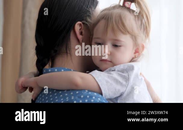 A little girl hugs a loving mother, a child calms down while sitting in ...