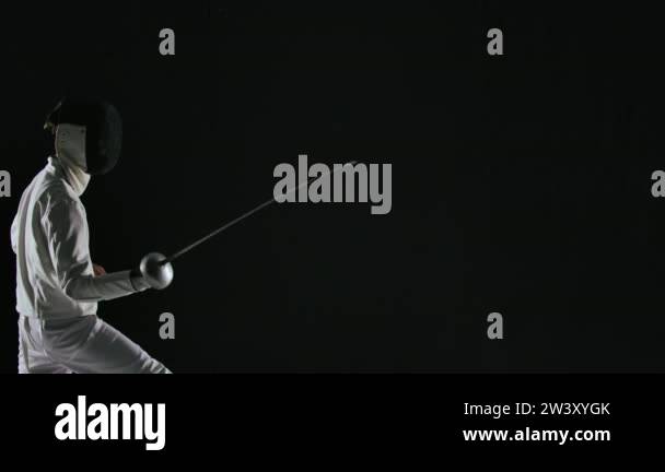 Side view of young boy in white uniform and mask masterfully wields ...