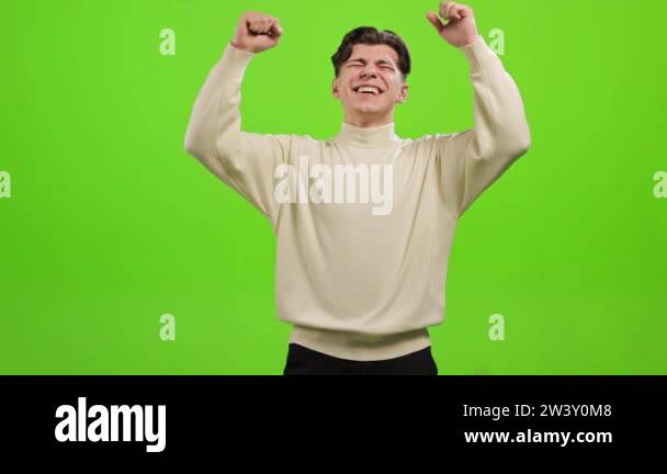 The man is standing and looking at the camera. He is raising his hands ...