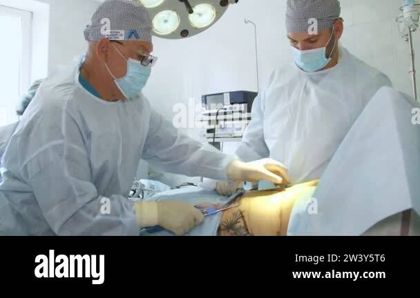 abdominal liposuction, surgery in actual operating room. surgeon pumps ...