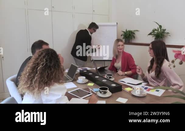 Smart boss showing flip chart and speaking with managers during ...