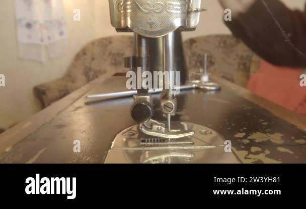 grandmother sews a red flag on an old sewing machine of the Soviet ...