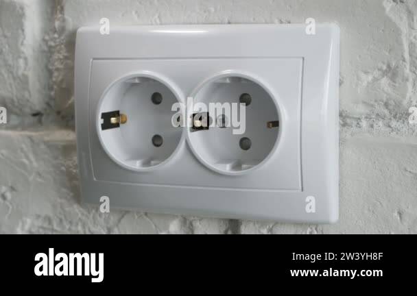 Inserting an Electrical Power Cord into a Socket on the Office Wall ...
