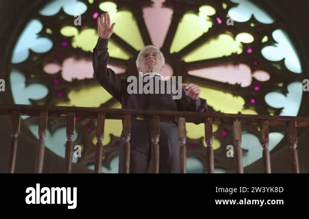 Low angle view of aged Caucasian clergyman wearing black clothes and ...
