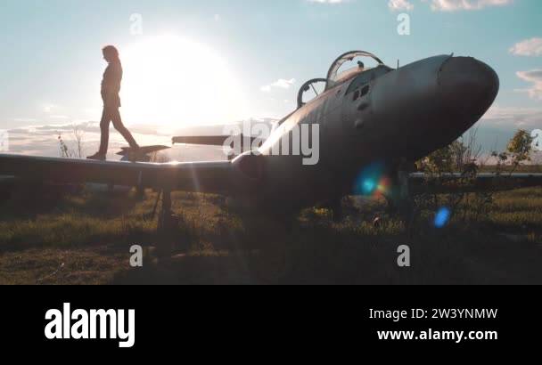 Medium view of tourist girl walking along wing of broken Soviet combat ...