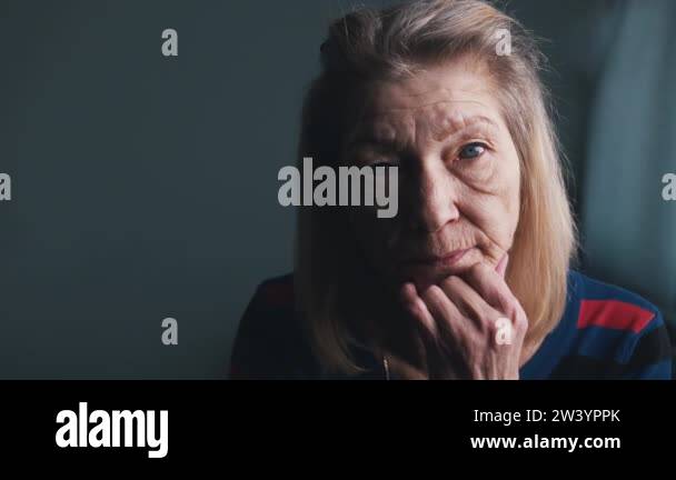 Portrait of lonely old woman with blue eyes gray hair and wrinkled skin ...