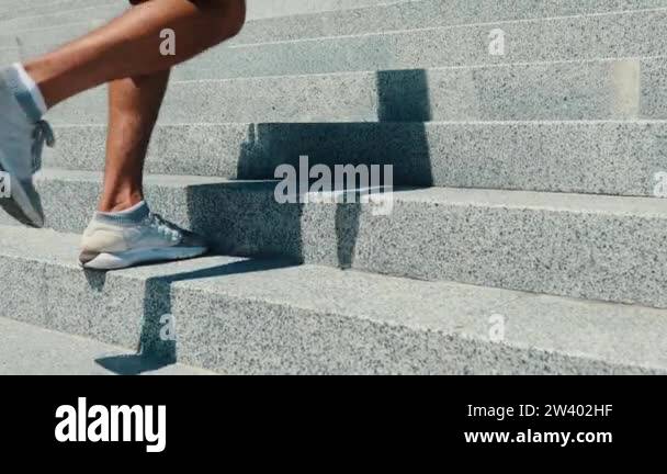 Young man exercising outside. Slow motion video of guy going up steps ...