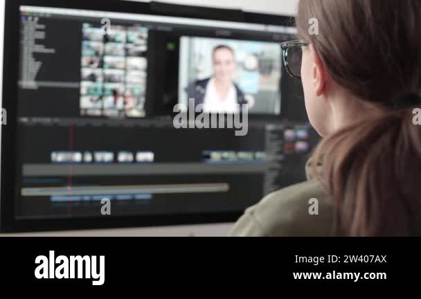 Female editor film working sitting in front of a computer monitor. The ...