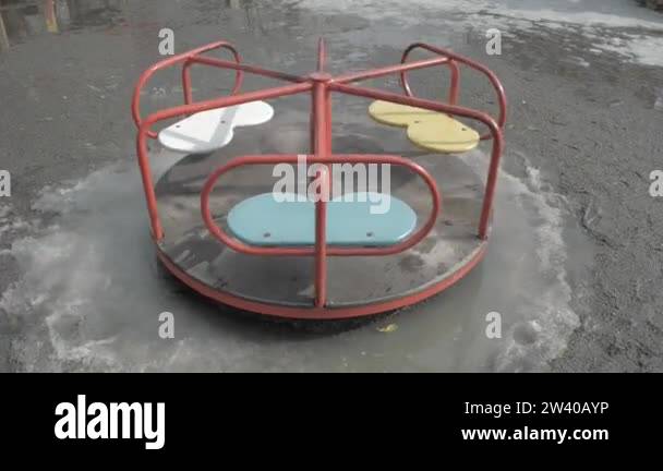 empty carousel in the playground spinning by inertia. early spring ...