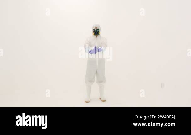 Man in white chemical protection suit and gas mask blows the party ...