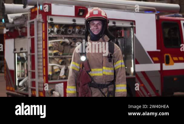 Middle plan of happy fireman in helmet and gull equipment cross arms ...