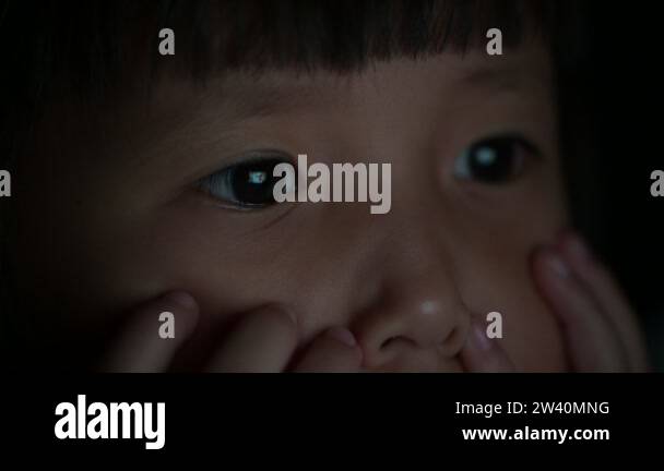 Eye close up Little Girl are watching video in tablet on bed at night ...