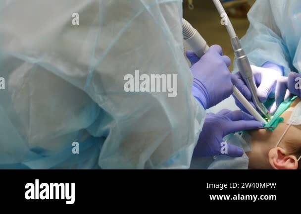 Close-up shot of dental operation performed in modern clinic. Teamwork ...