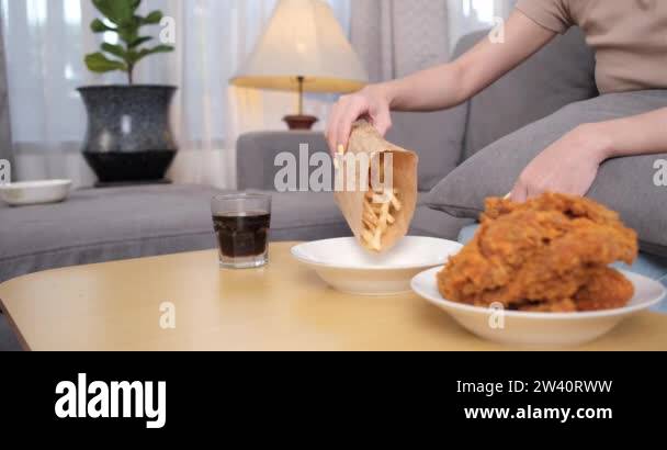 Young asian woman takeaway junk food eating chicken nuggets wings and ...