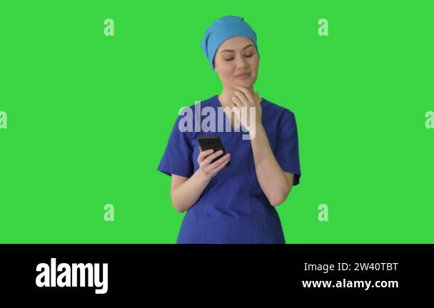 Thinking female doctor using her smartphone on a Green Screen, Chroma ...