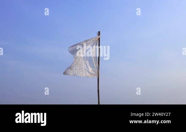 plastic flag blowing in the wind on the blue sky with clouds background ...