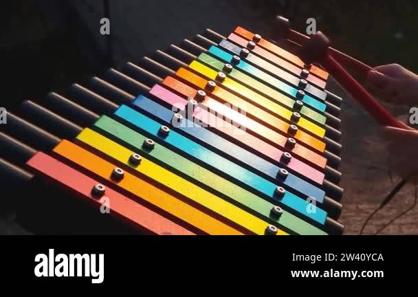 Playing the xylophone. A childs hand strikes the colorful keys of the ...