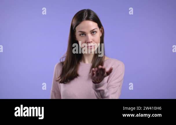 Young woman showing - Hey you, come here. Pretty girl in pink wear ask ...