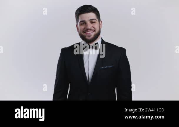 Cheerful man with beard in official wear - tuxedo nods his head ...