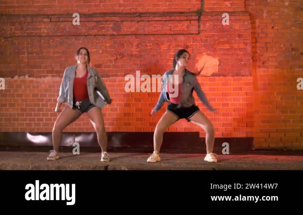 two beautiful cheerful women dancing modern choreography, street dance ...