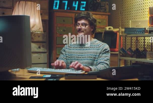 Caucasian male nerd in glasses with mustache sitting at desk in retro ...