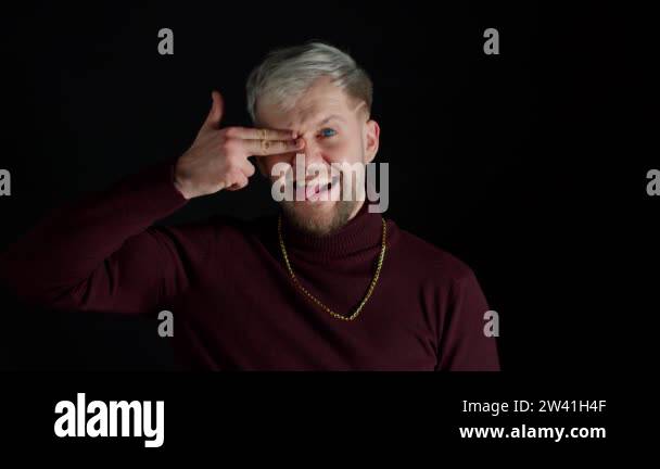Stylish man pointing with finger gun gesture, looking confident ...