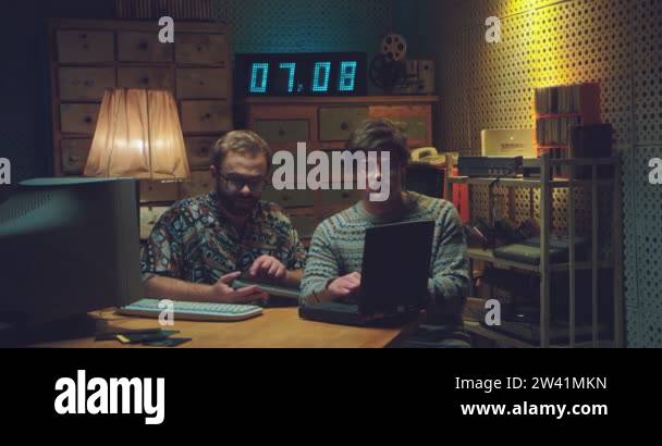 Caucasian males nerds sitting at table, talking and working on ...