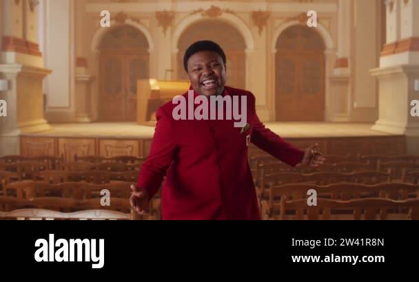 Crop view of gospel singer in red suit looking to camera and singing ...
