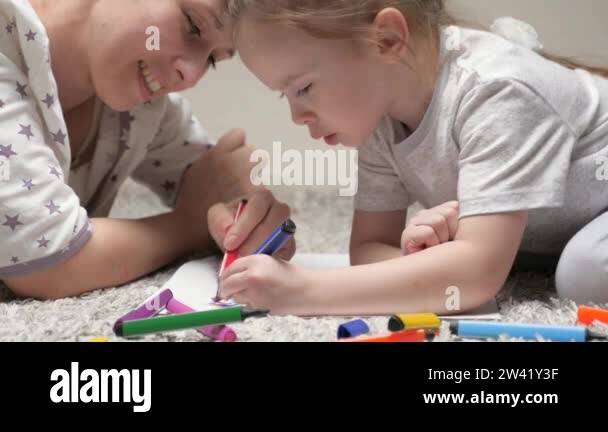 Child and Mom, nanny, teaches girl to draw. Happy family playing ...