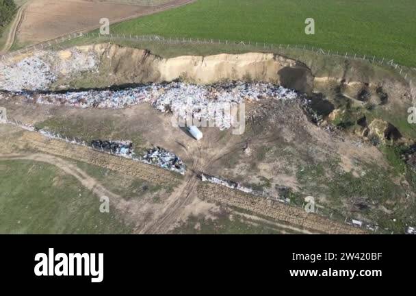 a dump landfill located near the wheat plantation, dumping waste in the ...
