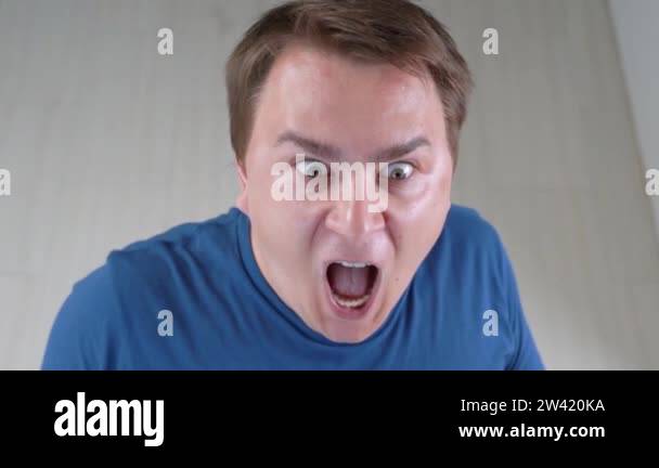 Young man in panic tries to cover his face with palms with outstretched ...