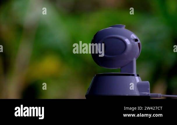 A white modern indoor CCTV camera with internal infrared is rotating to ...