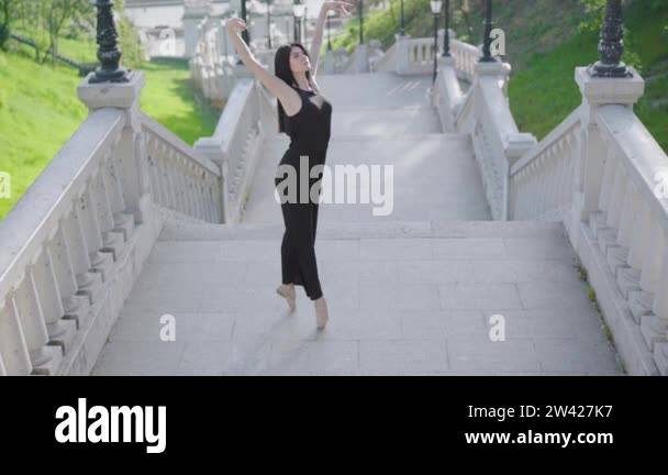 Top view of charming young ballerina walking on tiptoes, sitting down ...