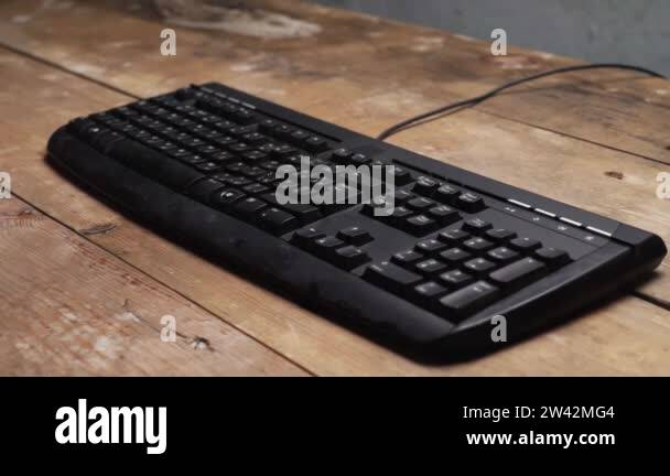 Angry man breaks the keyboard with a hammer. Furious worker breaks ...