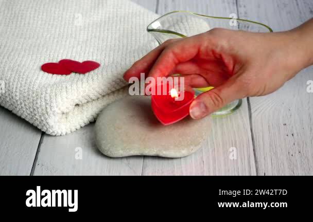 The concept of a Spa on Valentines Day. A beautician girl lights ...