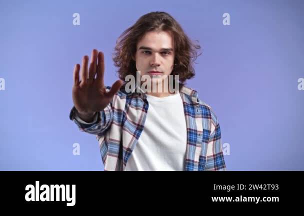 Portrait of serious man showing rejecting gesture by stop palm hand ...