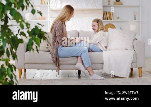 Young mother woman babysitter with little girl daughter sitting in ...
