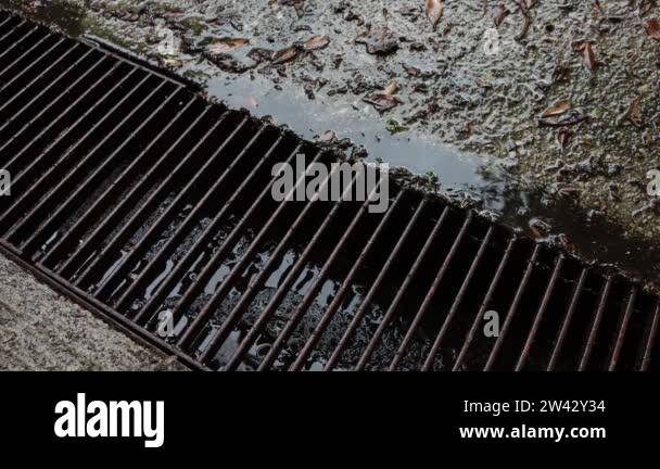 Close-up of rain water running down a metal drainage grate Stock Video ...