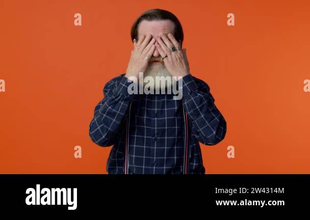 Elderly bearded old man closing eyes with hand showing stop gesture ...