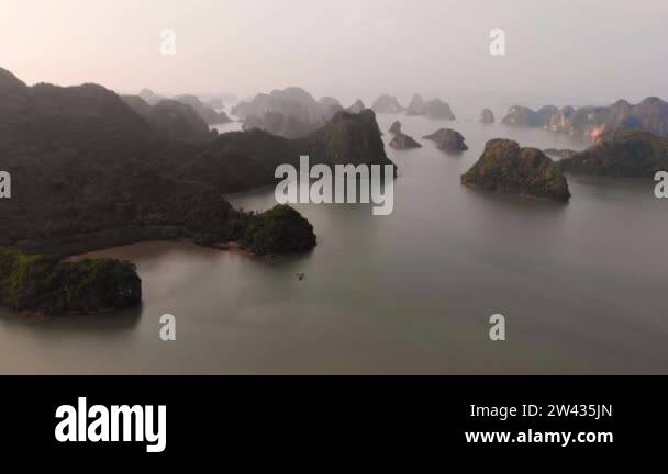 Aerial: flying over Ha Long Bay rock pinnacles at sunset, famous ...