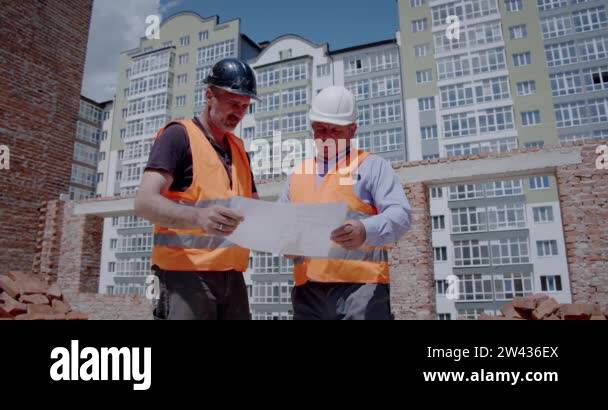 Construction manager and engineer working on building site ...