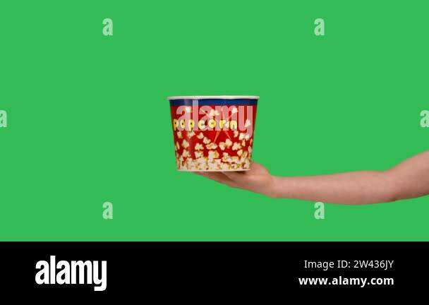 Female hands giving a bucket of popcorn close up. Woman points to the ...