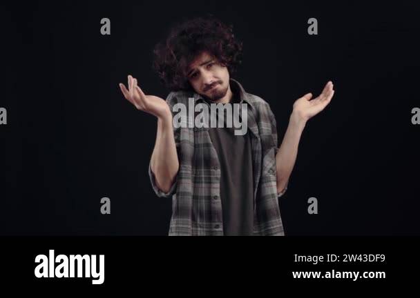 The charismatic young man raises his shoulders and hands in a sign of ... The charismatic young man raises his shoulders and hands in a sign of ...