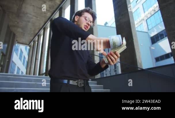 Portrait of happy funny Caucasian businessman scattering dollars while ...