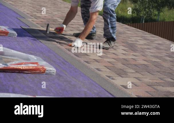 Roofing work. Laying a soft roof on the roof of a private house ...