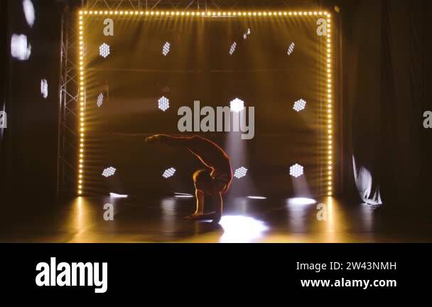 A flexible professional female athlete performs complex acrobatic ...