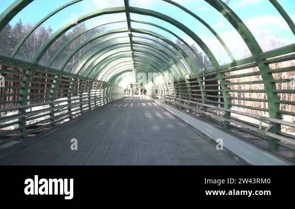 Walking Inside newly built modern pedestrian bridge over the highway ...